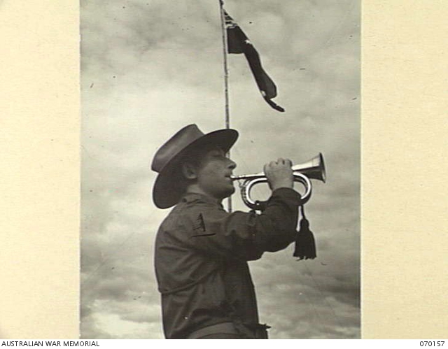 VX60958 Private Victor Alfred James Davis sounds “Reveille” as the flag ...