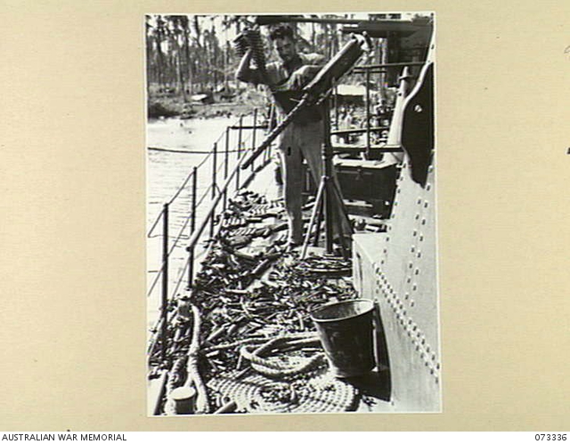 MADANG, NEW GUINEA. 1944-05-18. SIGNALMAN C. MCMANUS RE-LOADING A .50 ...