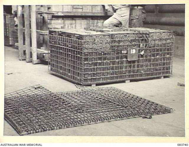 TRINITY BEACH, QLD. 1944-11-25. AN ARC MESH CRATE STANDS LOADED WITH ...