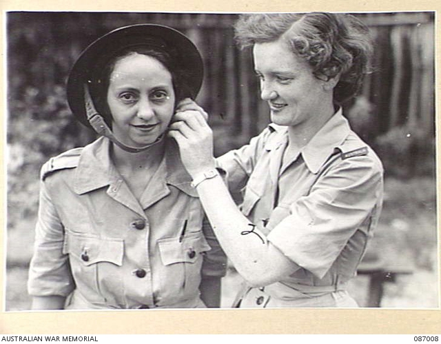 BRISBANE, QLD. 1945-02-21. PRIVATE B M WEBB, (1), HAS HER STEEL HELMET ...