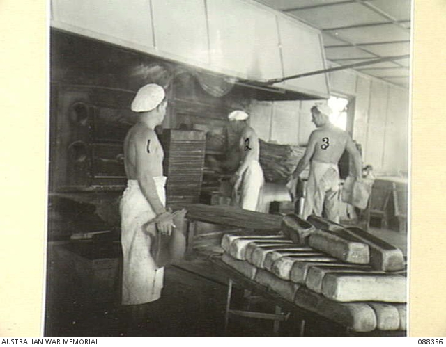 RAVENSHOE, QUEENSLAND. 1945-04-04. BREAD BEING REMOVED FROM THE OVENS ...