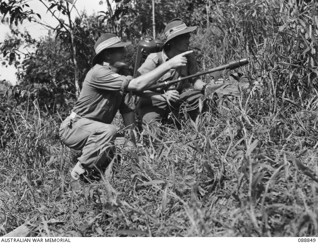 CORPORAL J. F. ARMSTRONG, 2/1 PIONEER BATTALION, (LEFT) INDICATING ...