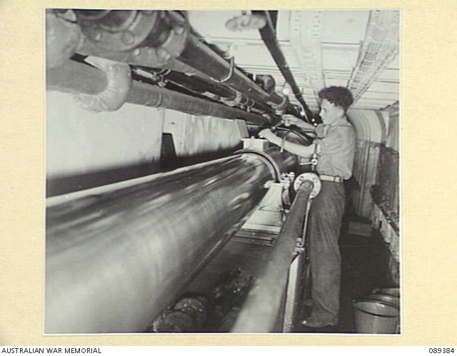 AT SEA, 1945-05-04. A RATING AT WORK ON THE STARBOARD SIDE OF THE MAIN ...