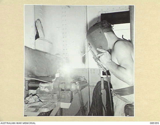 AT SEA, 1945-05-07/06. A LANDING CRAFT RAMP BEING WELDED IN THE LANDING ...