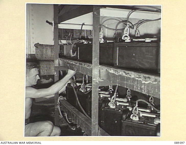 AT SEA, 1945-05-07. A RATING AT WORK IN THE LANDING CRAFT BATTERY ...