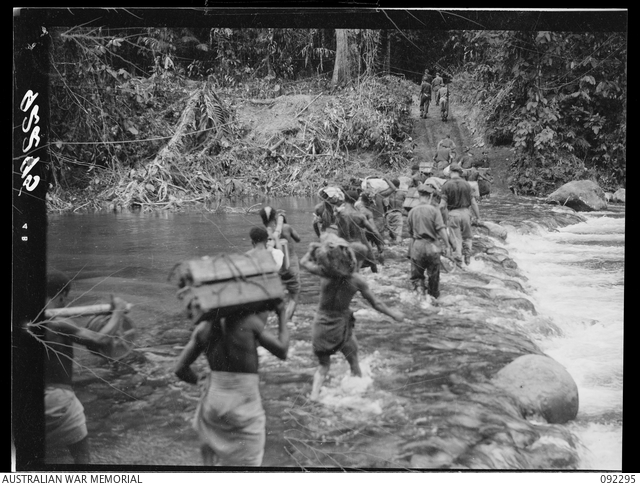 BOUGAINVILLE, 1945-05-17. A NATIVE CARRIER TRAIN PACKING AMMUNITION AND ...