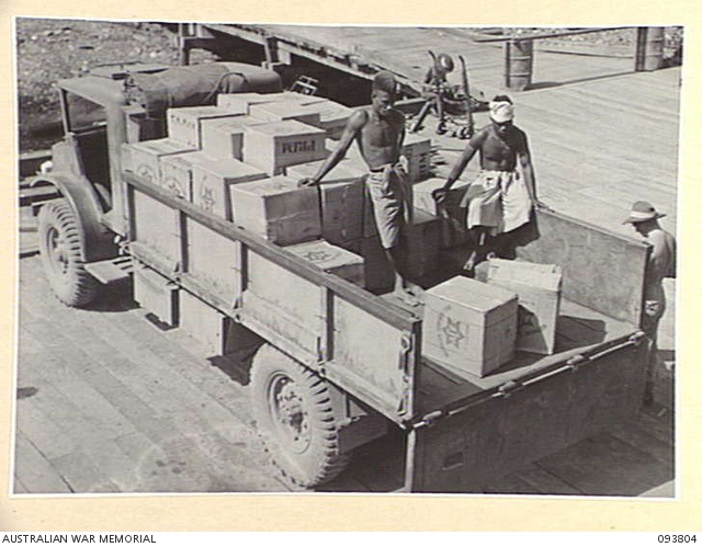 LAE AREA, NEW GUINEA, 1945-07-11. NATIVES ASSISTING WITH THE UNLOADING ...