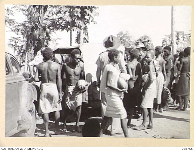 RABAUL, NEW BRITAIN. 1945-11-10. FRUIT BEING PLACED INTO JEEPS BY ...
