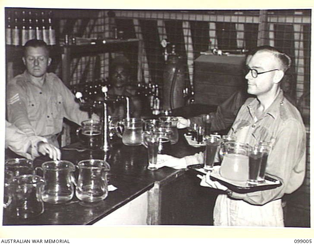 LAE, NEW GUINEA. 1945-11-25. SERGEANT WAPPET SERVING DRINKS AND PRIVATE ...