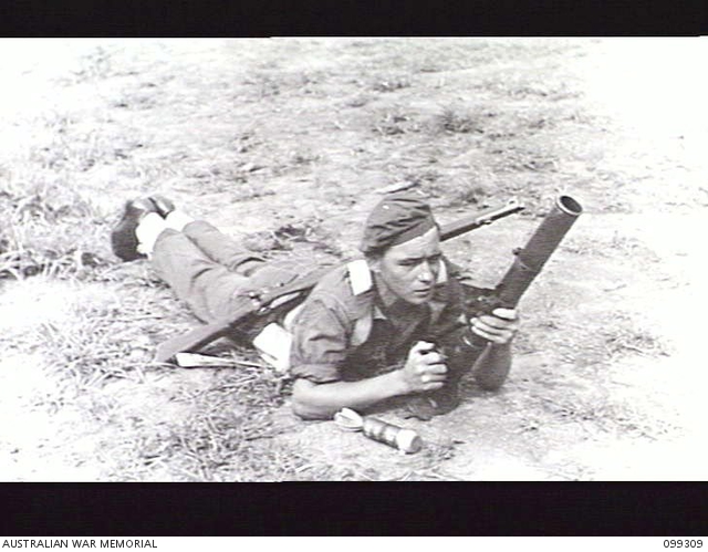 RABAUL, NEW BRITAIN, 1945-12-06. A SOLDIER HOLDING A 2-INCH MORTAR IN ...