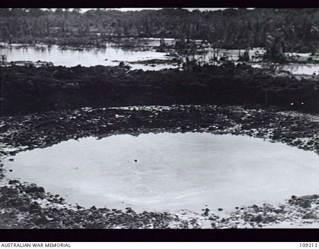 TARAKAN ISLAND. 4 JUNE 1945. LARGE BOMB CRATERS IN THE SWAMP AREA AT ...