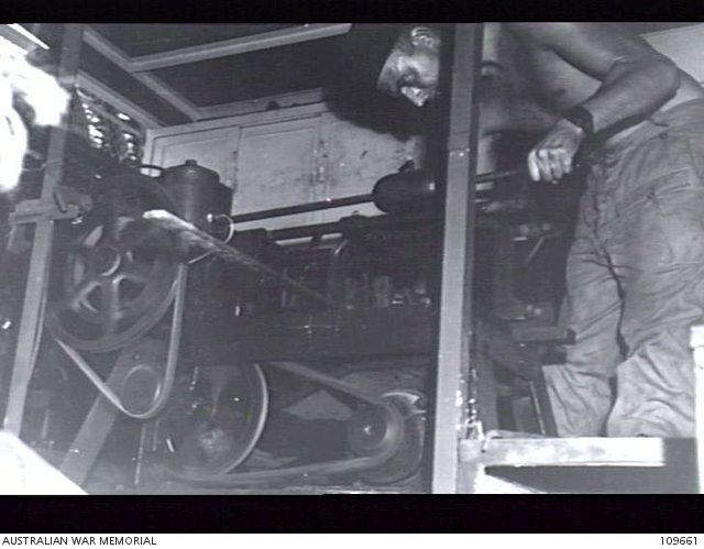 TARAKAN ISLAND. 19 JUNE 1945. CRAFTSMAN J GUNNING OPERATING A POWER ...