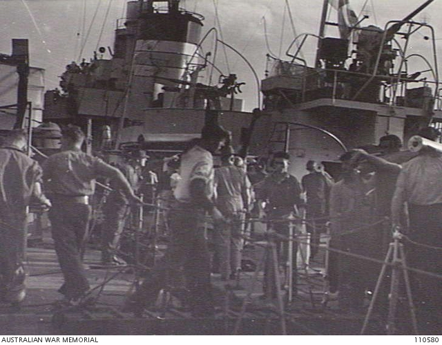 AT SEA. 23 JUNE 1945. NAVY PERSONNEL TRANSFERRING 4.7 INCH AMMUNITION ...