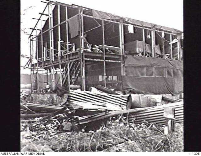 BALIKPAPAN, BORNEO, 10 JULY 1945. A PARTIALLY WRECKED BUILDING WHICH IS ...