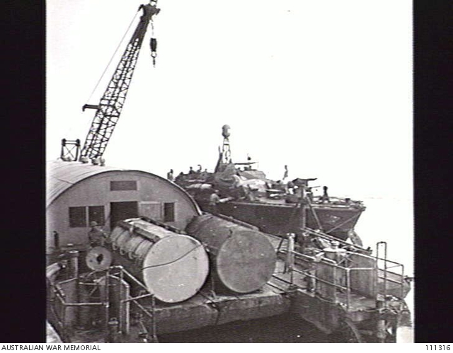 BALIKPAPAN, BORNEO, 12 JULY 1945. A UNITED STATES NAVY CRAFT TIED UP AT ...