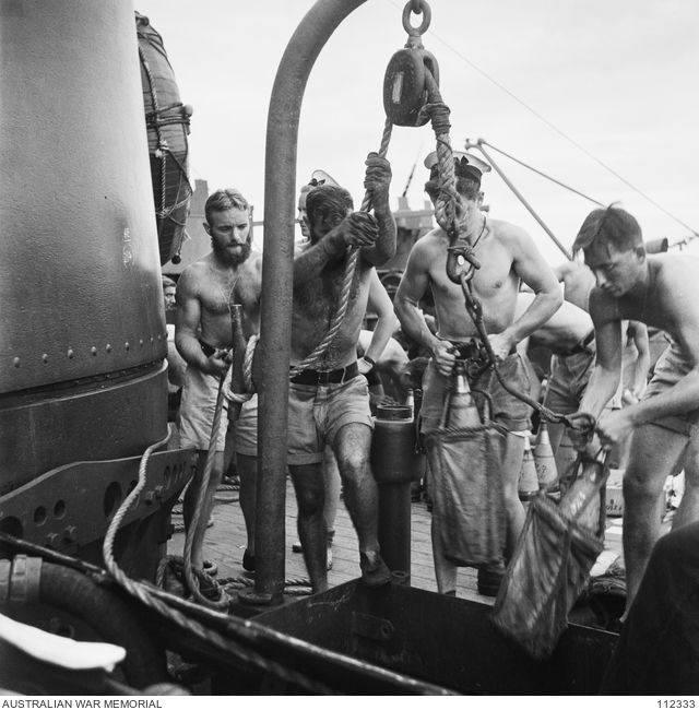 TAWI TAWI ISLAND. 1945-06-14. MEMBERS OF THE CREW STORING 6" SHELLS IN ...