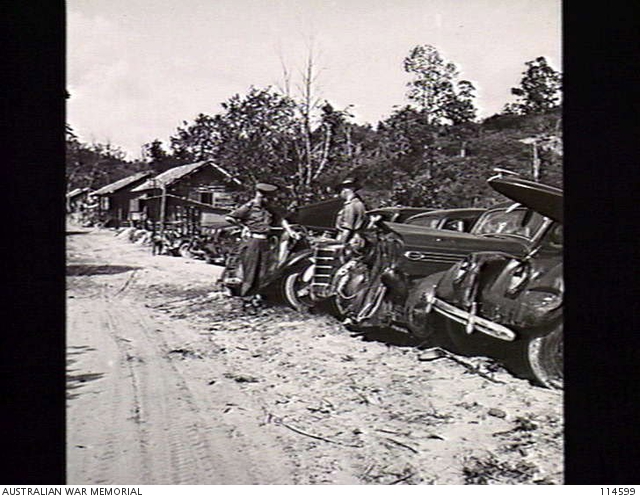 BALIKPAPAN, BORNEO. 1945-08-25. A LINE OF WRECKED CARS ABANDONED BY ...