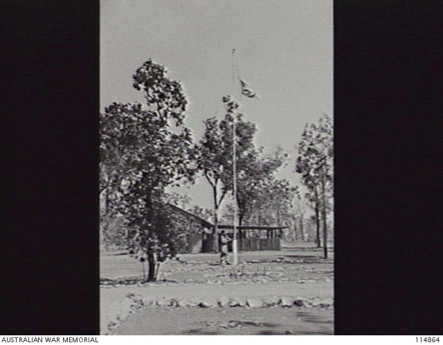 WINNELLIE, NT. 1945-09-05. THE UNIT FLAG BEING LOWERED AT HEADQUARTERS ...