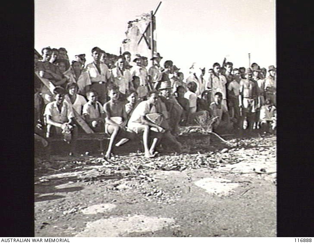 MANADO, CELEBES. 1945-09-14. LOCAL NATIVES GATHERED AT THE WHARF TO ...