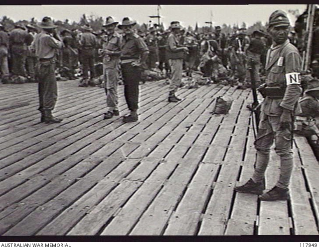 BANJERMASIN, BORNEO. 1945-09-17. A JAPANESE GUARD NERVOUSLY STANDS AT ...
