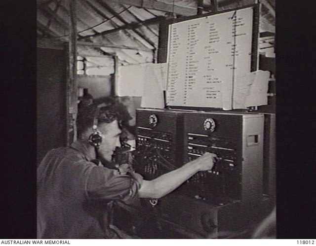 LABUAN ISLAND, BORNEO. 1945-10-10. SIGNALLER G. D. MCCUAIG OPERATING A ...