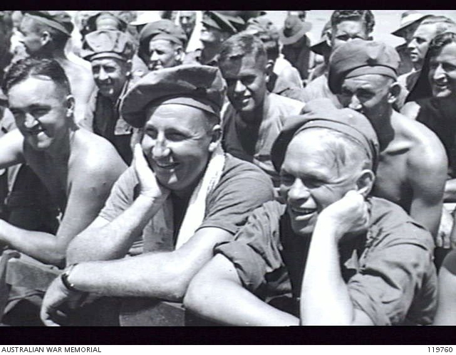 CHANGI,SINGAPORE 1945-10-01. A GROUP OF EX PRISONERS ATTENTIVELY ...