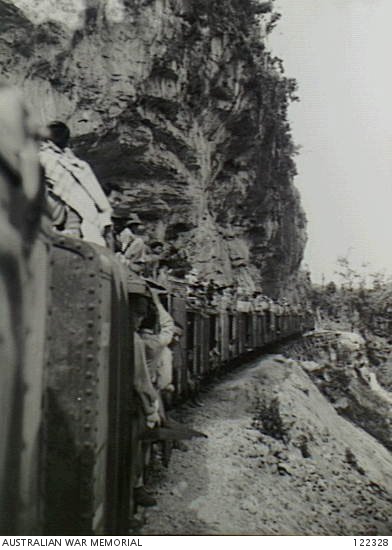A train loaded with natives passing over the long trestle bridge ...
