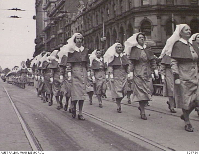 MELBOURNE, VIC 1945-11-29. A GROUP OF NURSES MARCHING PAST THE SALUTING ...