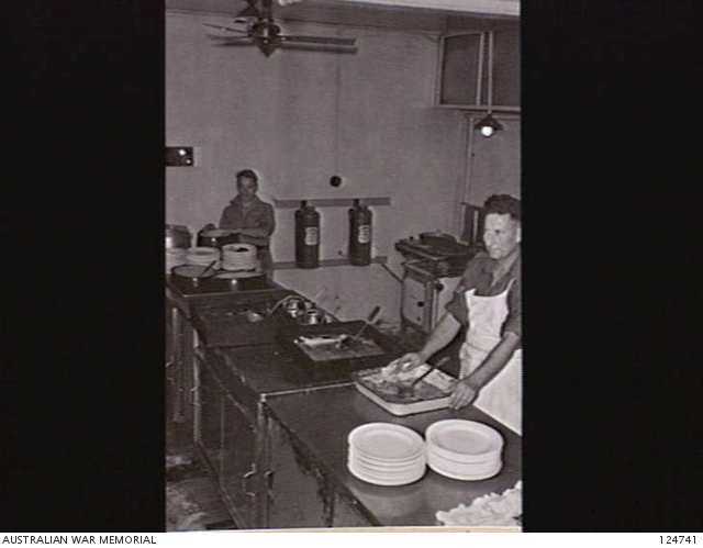 MELBOURNE, VIC 1945-12-07. A SERGEANT COOK AND ASSISTANT IN THE KITCHEN ...