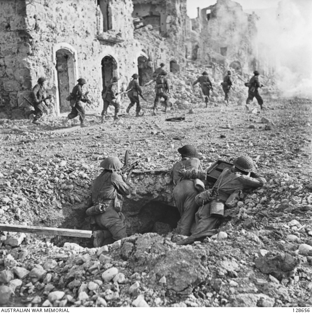 AQUINO, ITALY. 1944. COVERED BY MACHINE GUNNERS AND RIFLEMEN IN A SHELL ...