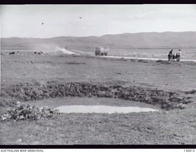 DOMOKOS, GREECE. 1945-04-23. BOMB CRATERS BESIDE THE ROAD LEADING INTO ...