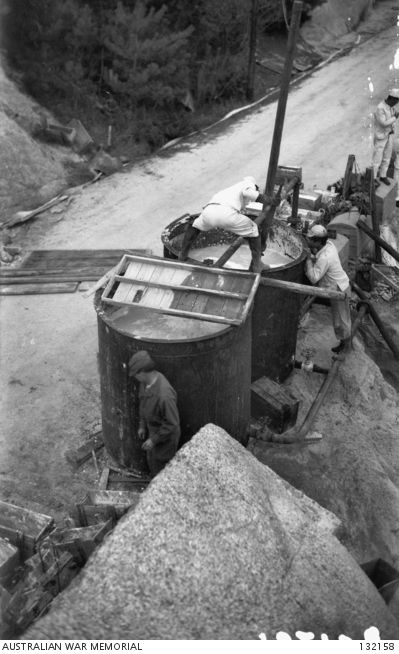 OKUNOSHIMA, JAPAN. 1946-10-03. JAPANESE LABOURER STIRRING BLEACH SLURRY ...