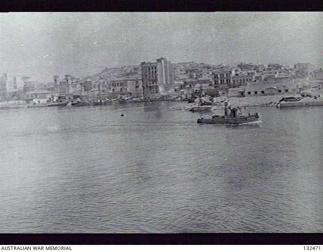 PIRAEUS, GREECE. 1945-07. A GREEK TUG BOAT IN THE HARBOUR WITH THE CITY ...