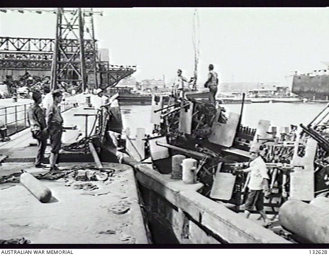 KURE, JAPAN. 1946-09-05. ACK ACK GUNS FOR SALVAGE ARE BEING LOADED ON ...