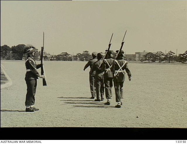 TOKYO, JAPAN. 1947. THE NEW SENTRY PRESENTS ARMS AS THE FIRST RELIEF ...