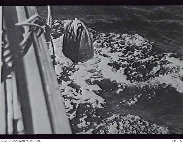 TORPEDO ABOUT TO BE HOISTED ABOARD A TORPEDO RECOVERY LAUNCH. WAKE ...