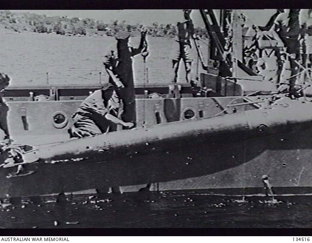 A TORPEDO BEING HOISTED BY CRANE ABOARD A TORPEDO RECOVERY LAUNCH ...