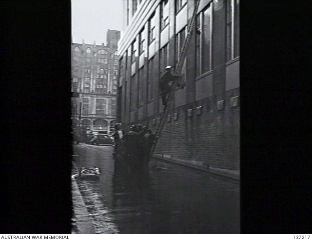 MELBOURNE, VIC. 1942-12-05. AN AIR RAID PRECAUTION WARDEN CLIMBS A ...