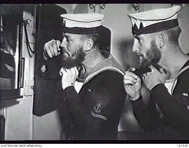 Two crew members of HMAS Napier carefully comb their beards before ...