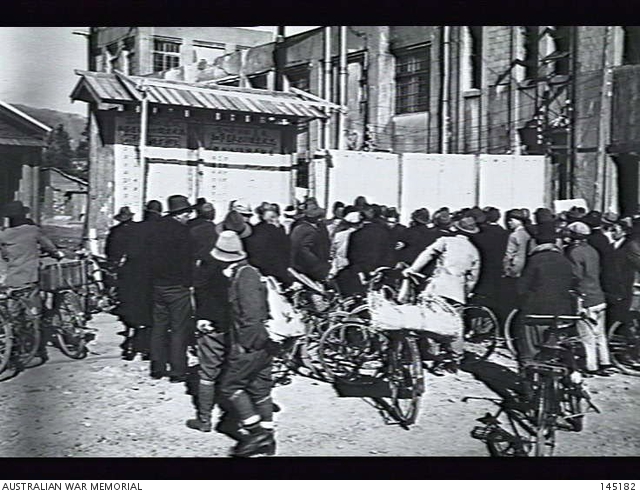 Kochi (Shikoku), Japan. 1948-01-10. Japanese civilians stop to look at ...