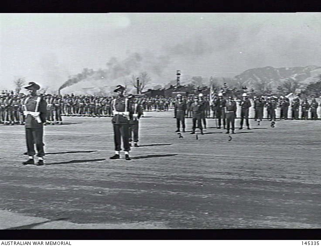 Kure, Japan. 1948-02-20. Members of the forces stand at ease listening ...