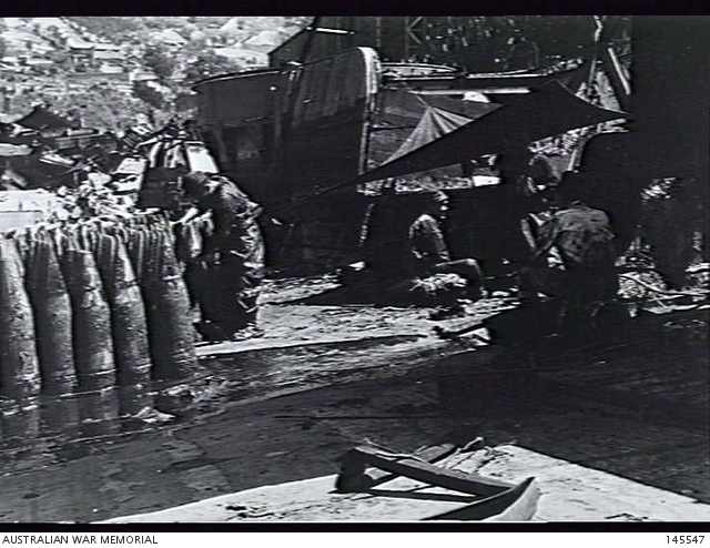 Kure, Japan. 1948-07-01. Japanese labourers hauling and stacking shells ...