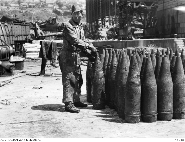 Kure, Japan. 1948-07-01. Japanese labourer stacking shells from the ...