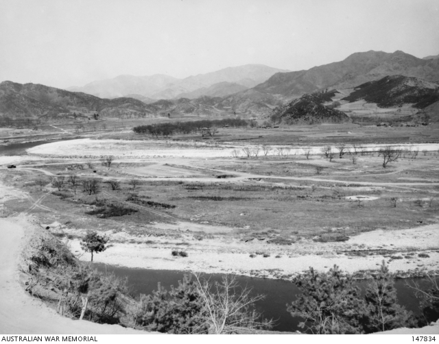 Kapyong Valley, Korea. 1952-04-16. A jeep travelling on the road above ...