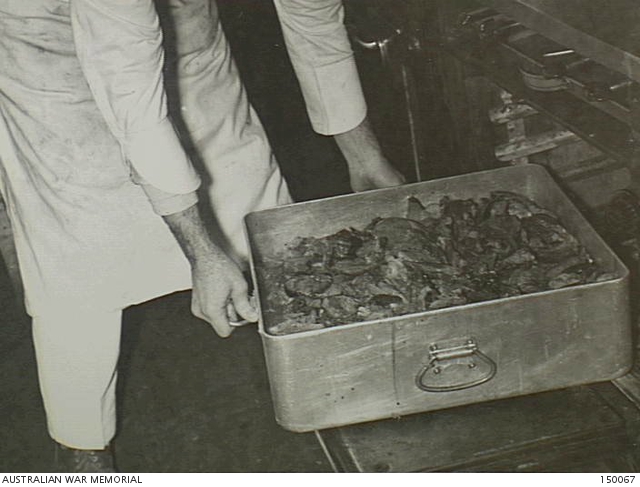 Australia. 1942. A cook at a US Army camp prepares a meat dish for the ...
