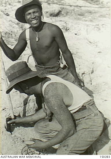 An Australian sapper preparing a charge of explosive with the help of a ...
