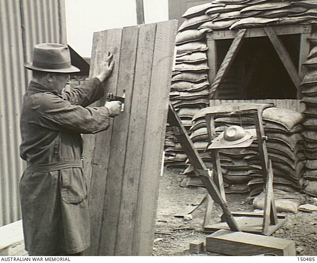Australia. August 1942. An inspector at a munitions annexe carries out ...
