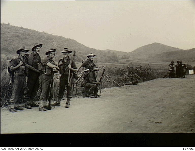 Majon'ni, Korea. 1953-07-30. Soldiers rest on the side of the road ...