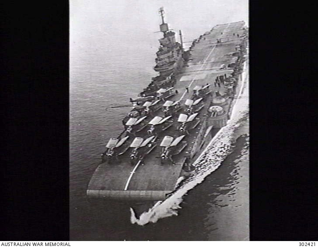 C.1942. AERIAL BOW VIEW OF THE AIRCRAFT CARRIER HMS INDOMITABLE. SHE IS ...