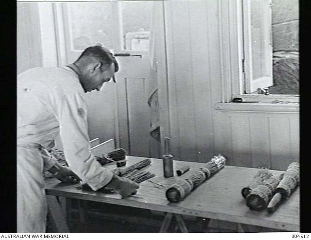 A TECHNICIAN SORTING CORDITE STICKS AT AN ORDNANCE DEPOT IN PREPARATION ...